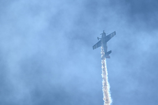 Doug Littonの展示飛行（Extra EA-300S） : 青い郊外の空の下・黄色と緑のセロファンの花たち